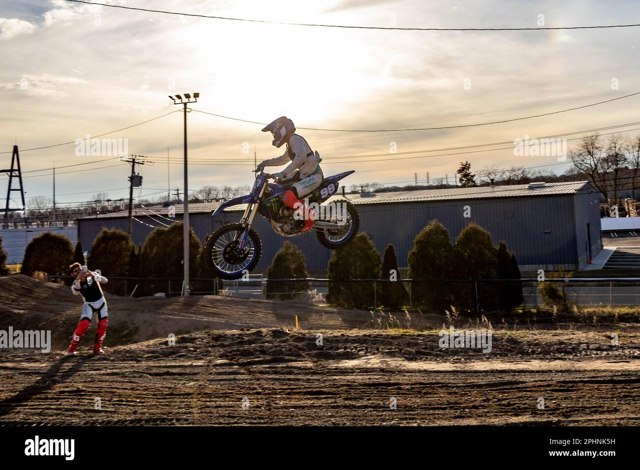 A young adult performing a risky stunt, with an off-road motorcycle, by ...
