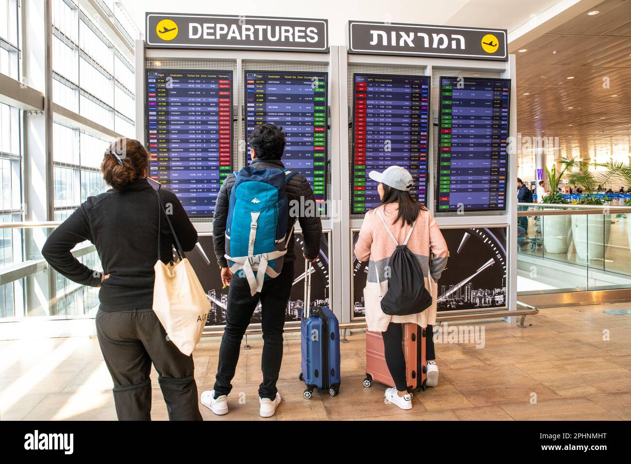 Passengers looks at flights announcement board showing delayed flights ...