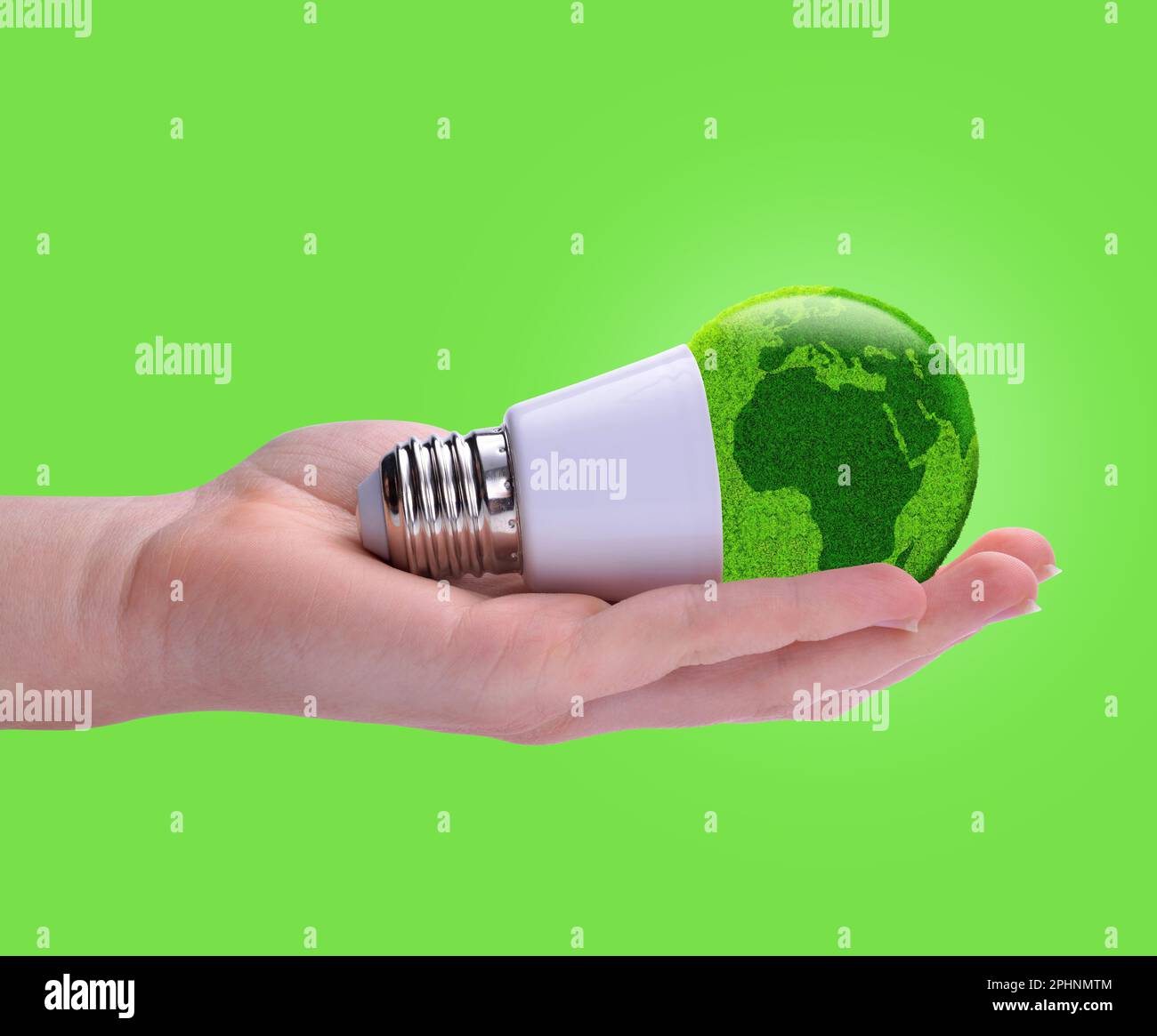 Eco LED bulb in hand isolated on a green background. Green energy ...