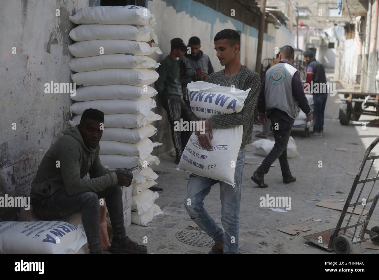 Gaza. 29th Mar, 2023. A Palestinian worker carries a sack of flour ...