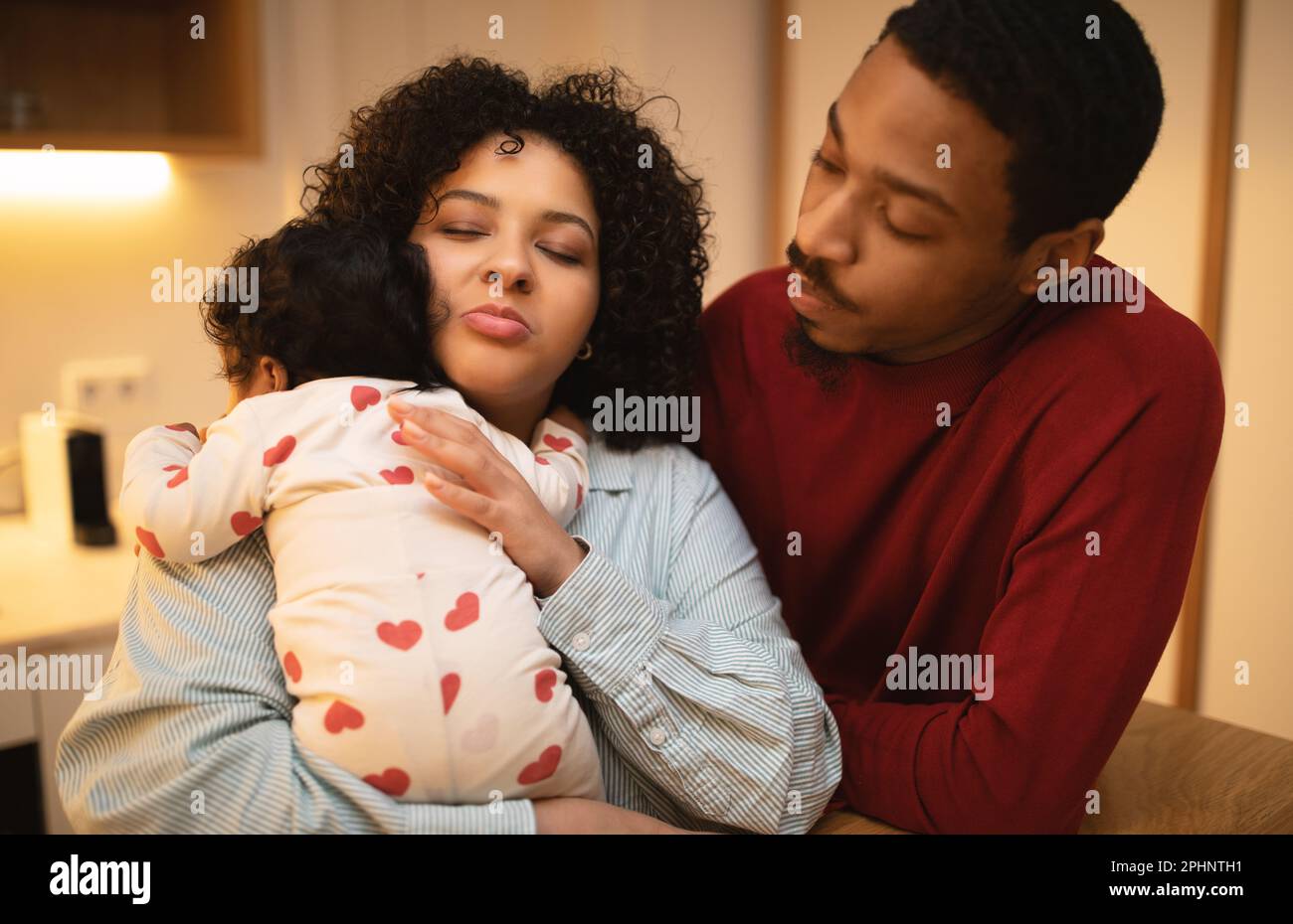 Portrait of multicultural young couple posing with their newborn baby ...