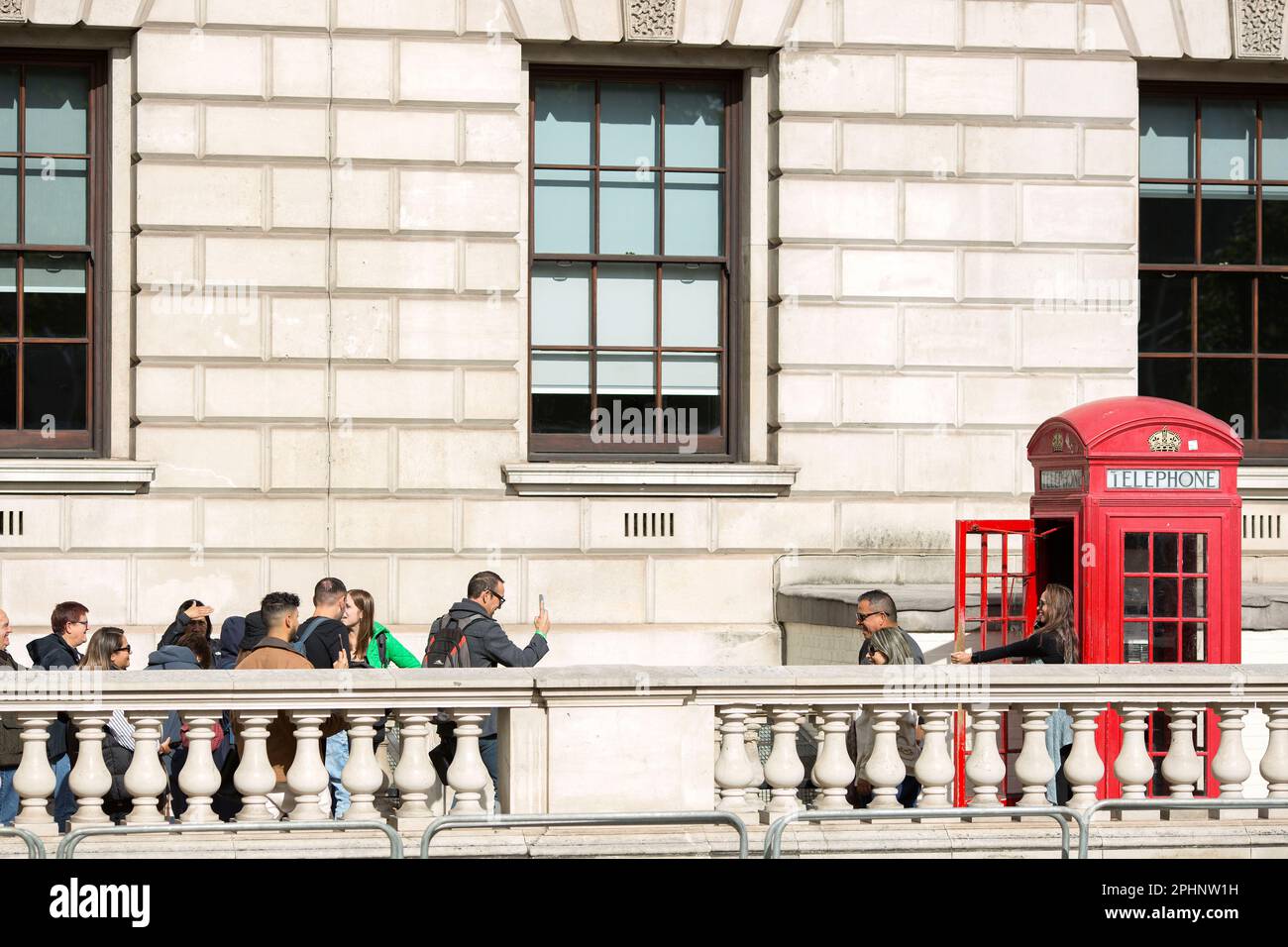 People queue to take photographs next to a red telephone box in ...