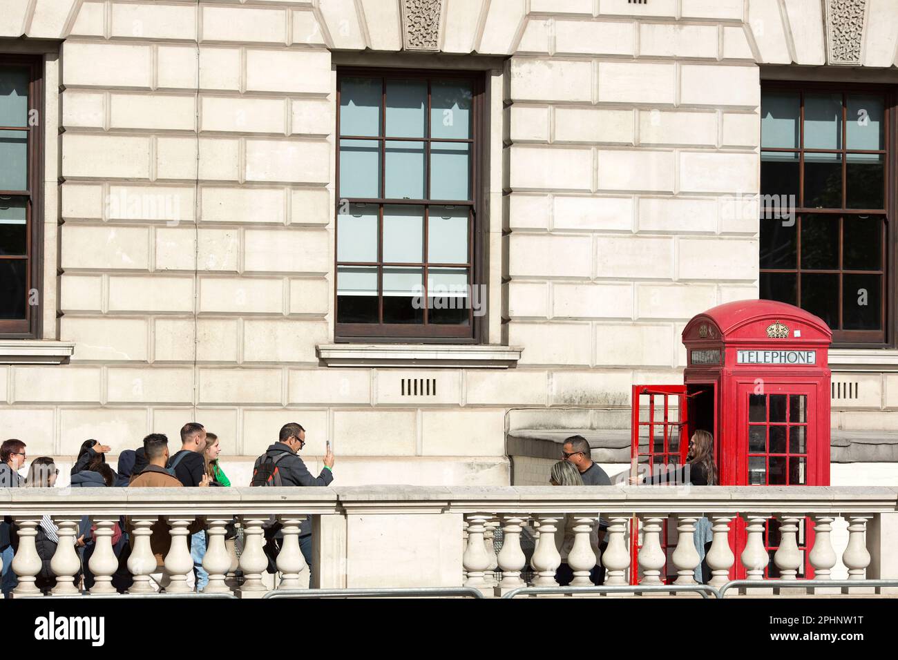 People queue to take photographs next to a red telephone box in ...