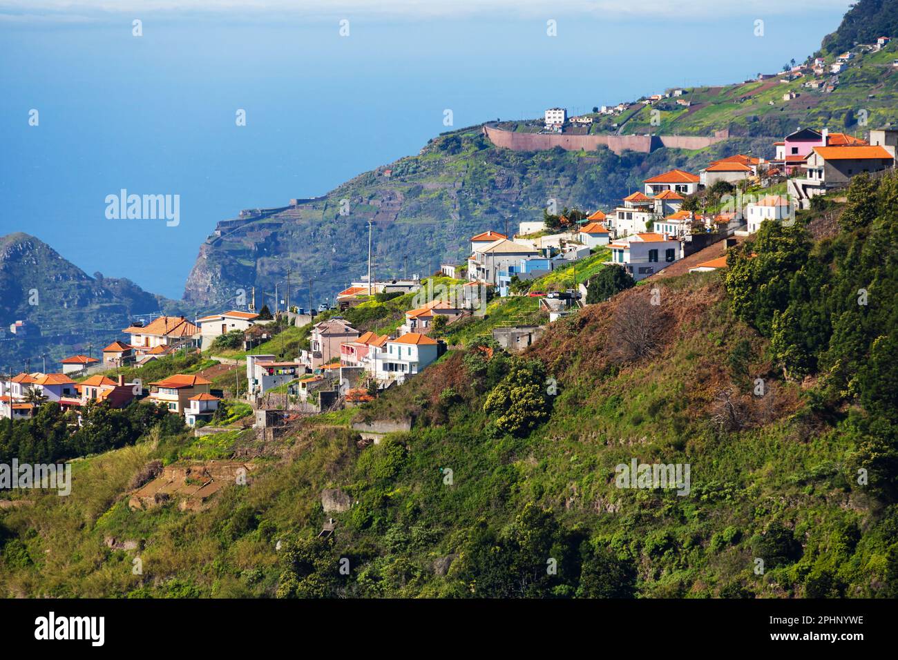 village houses cling to the hillside where the sea meets the sky ...