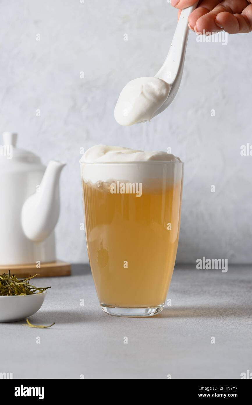 Woman cooking Cheese tea with whipped cream cheese foam on white ...
