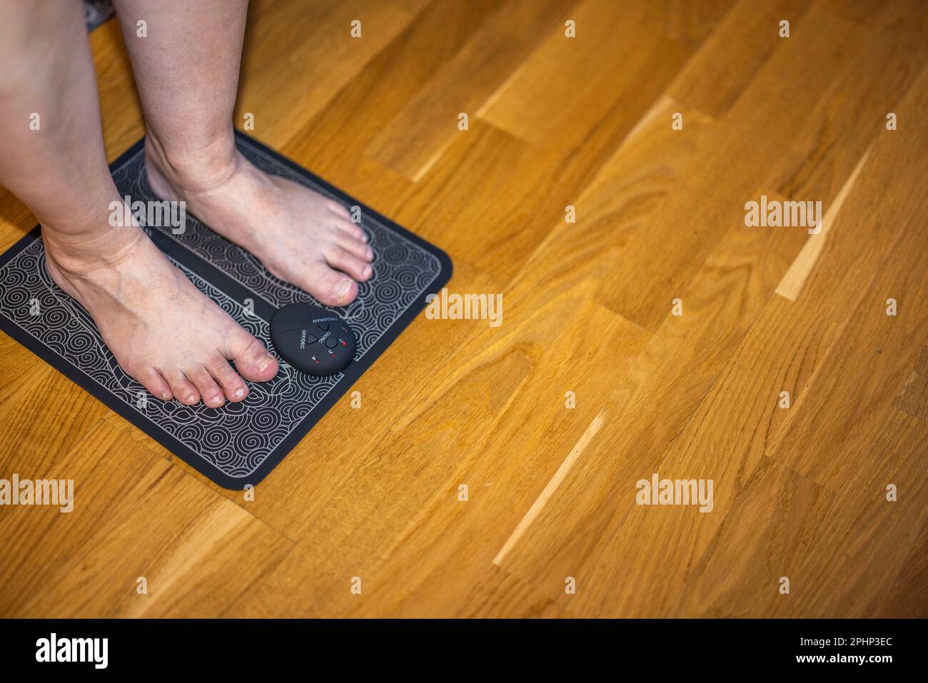 Close up view of woman's feet on electrical ems foot massager pad. Feet ...