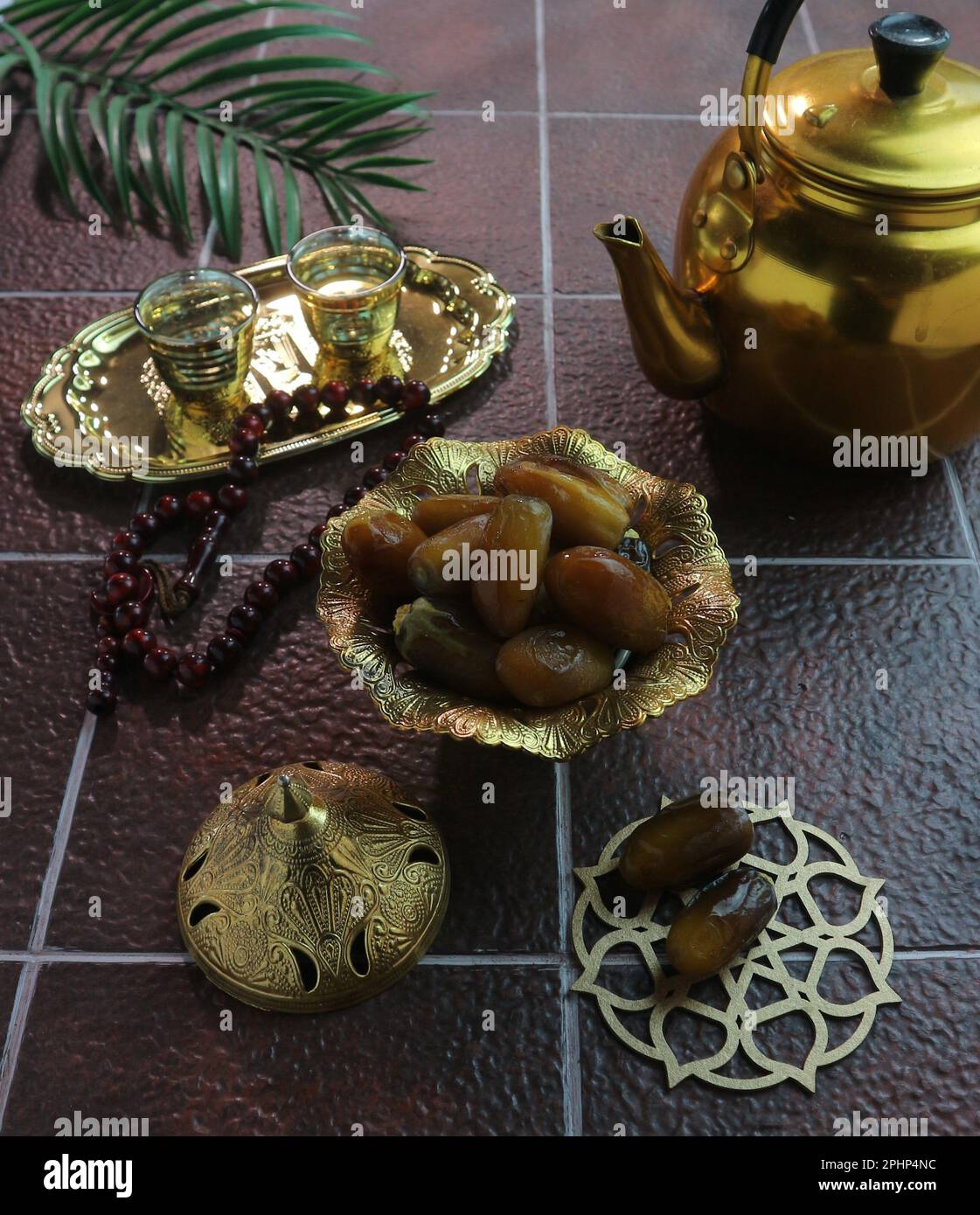 serving of dates in a gold bowl against a background of glasses on a ...