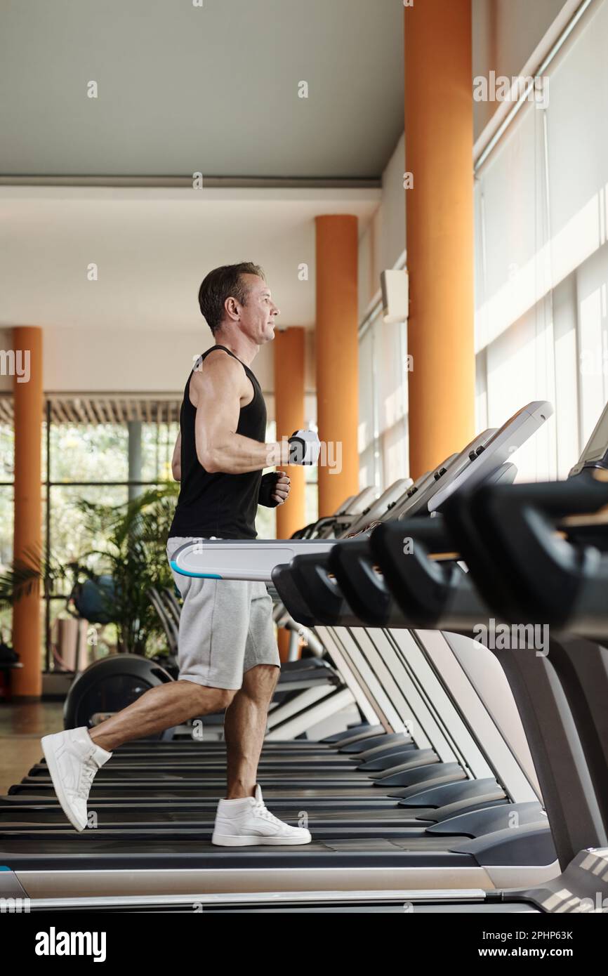 Sportsman running on treadmill to warm up before training Stock Photo ...