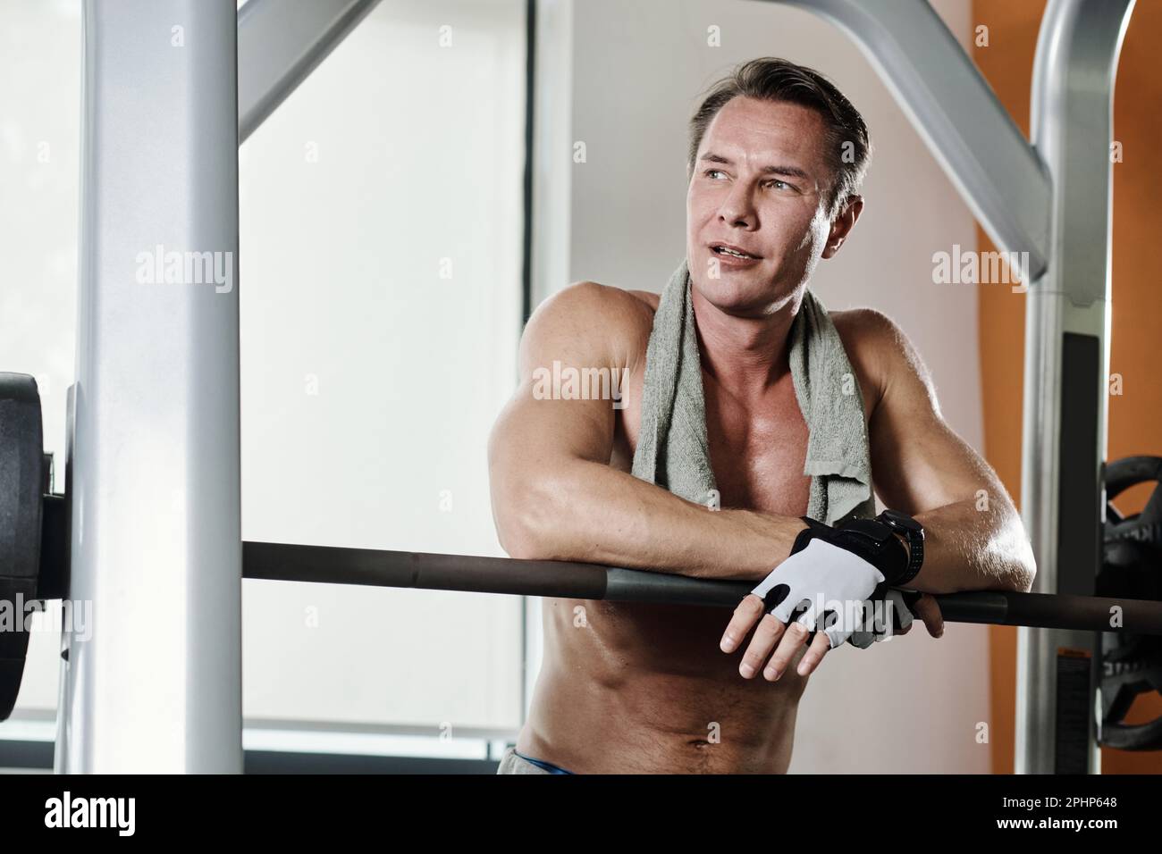 Sweaty tired sportsman leaning on barbell after doing exercise Stock ...