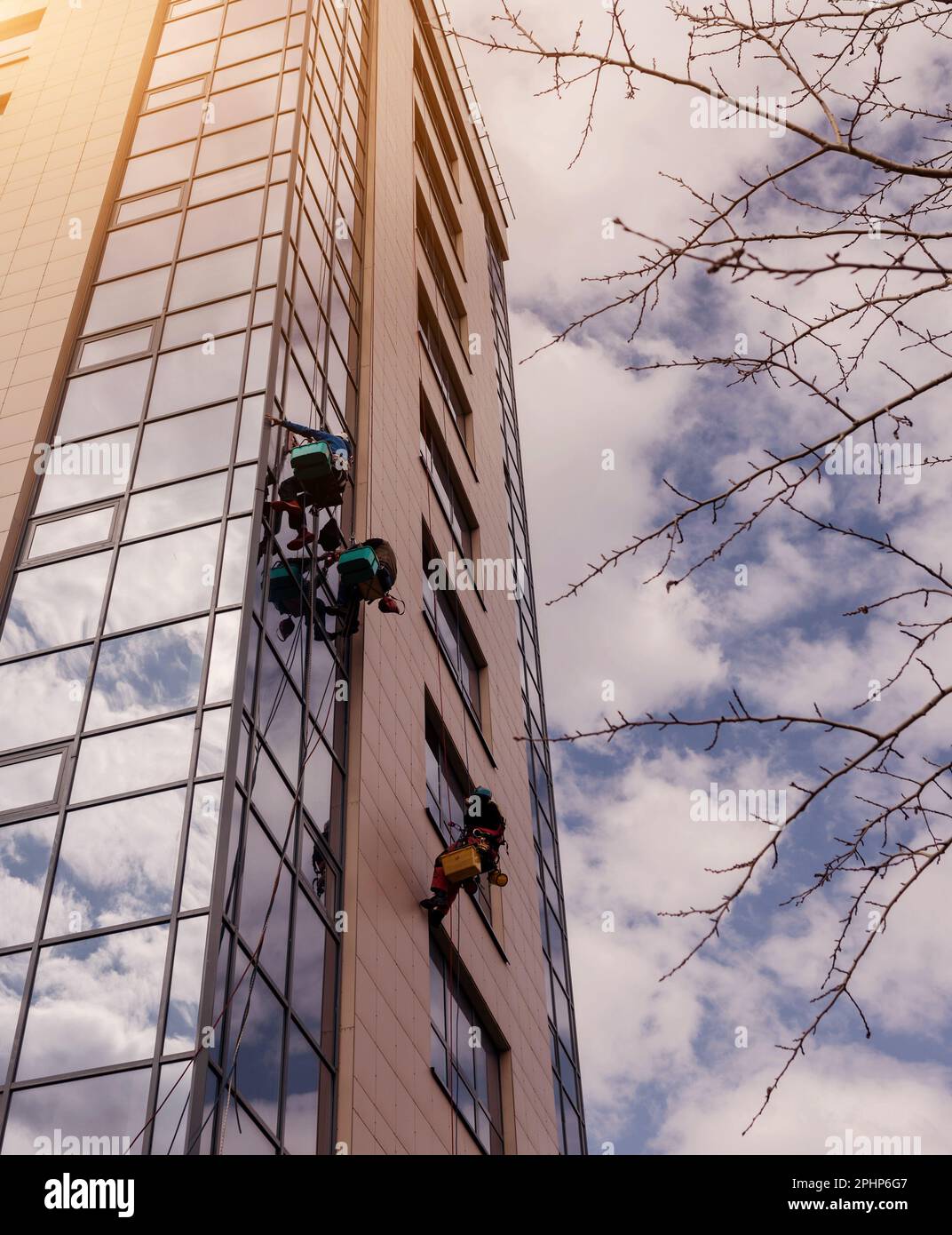 group of workers cleaning windows service on high rise building ...