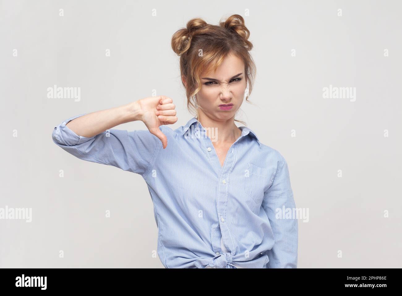 Portrait of disappointed blonde woman shows disapproval sign, keeps ...