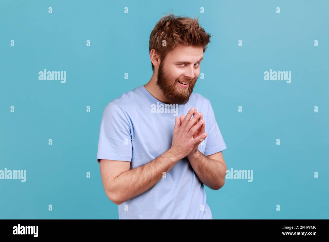 Portrait of cunning bearded man schemes something keeps hands together ...
