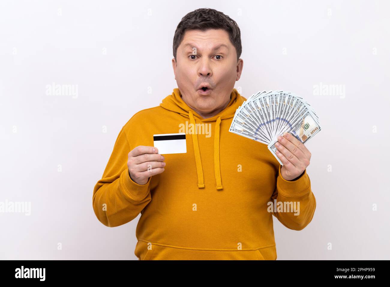 Shocked middle aged man holding and showing dollar cash and credit card ...