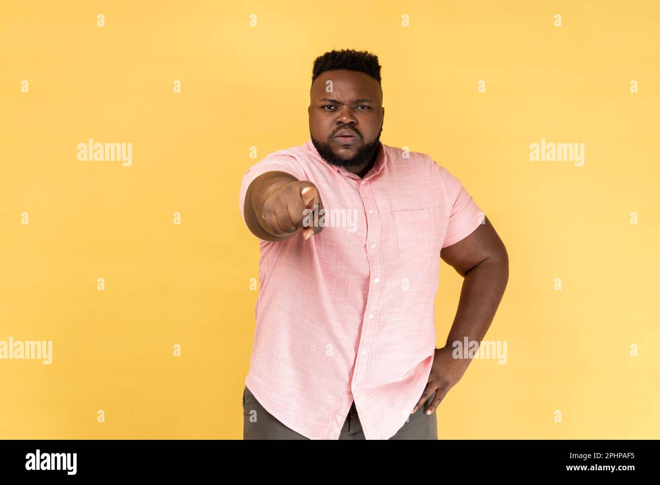 Portrait of bearded young adult man wearing pink shirt noticing and ...