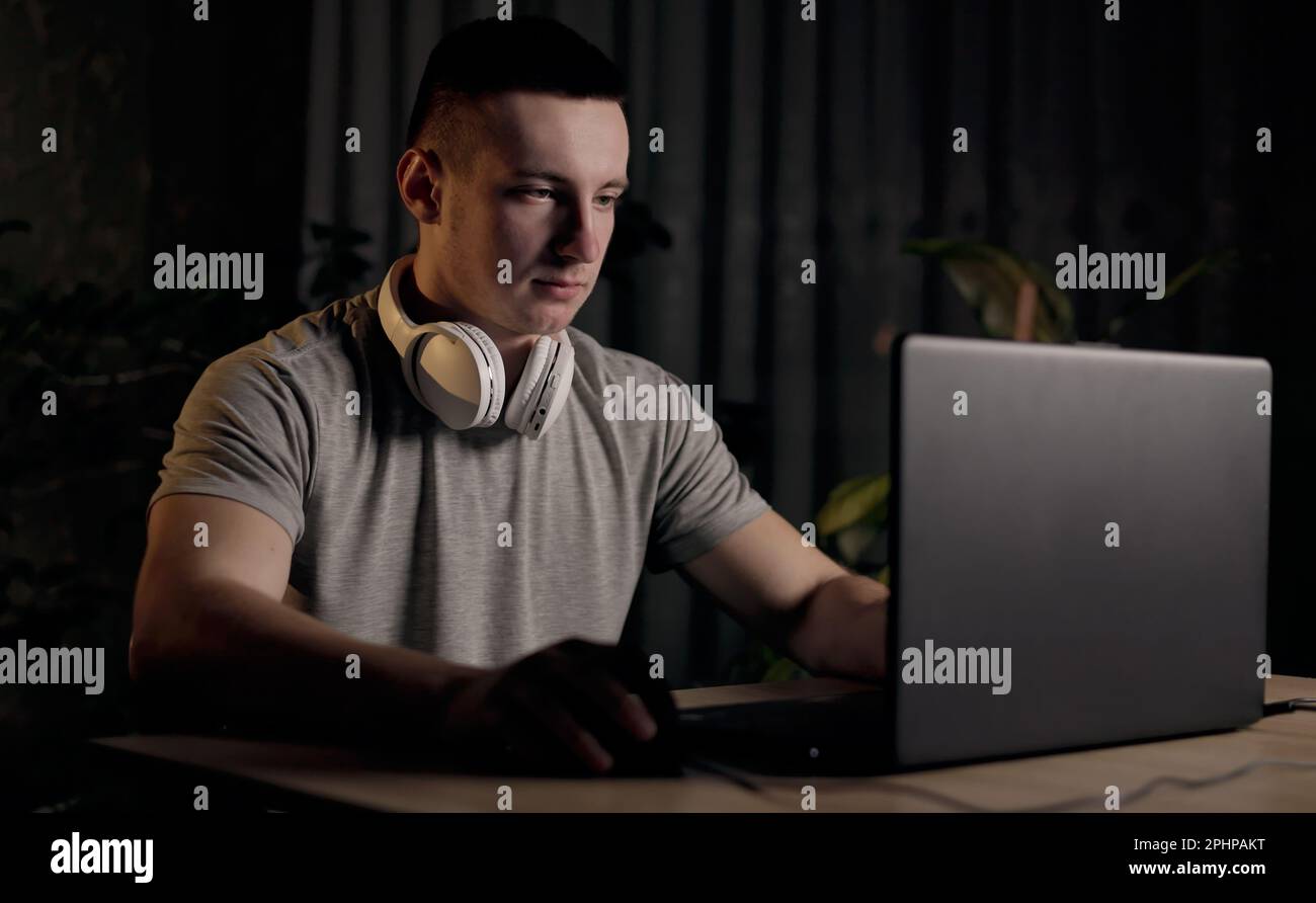Young man freelancer using laptop, typing, scrolling, surfing web ...