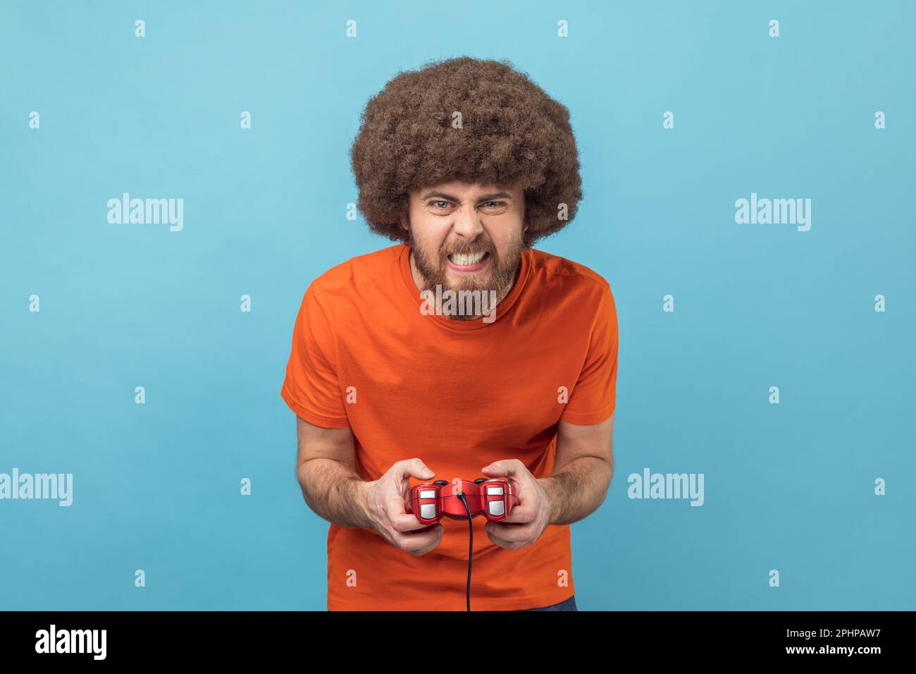 Portrait of crazy funny man with Afro hairstyle grimacing holding ...