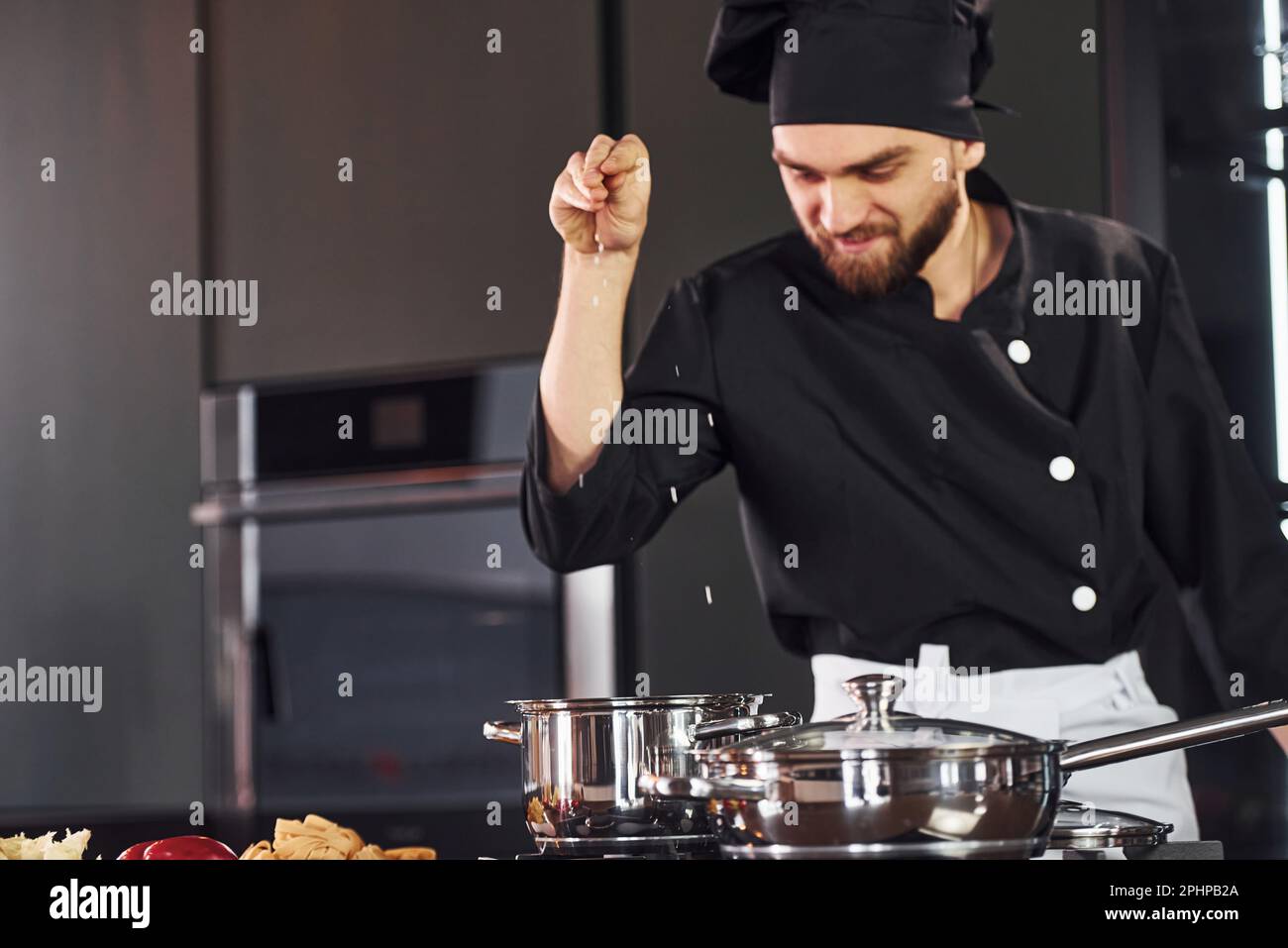 Using equipment. Professional young chef cook in uniform working on the ...