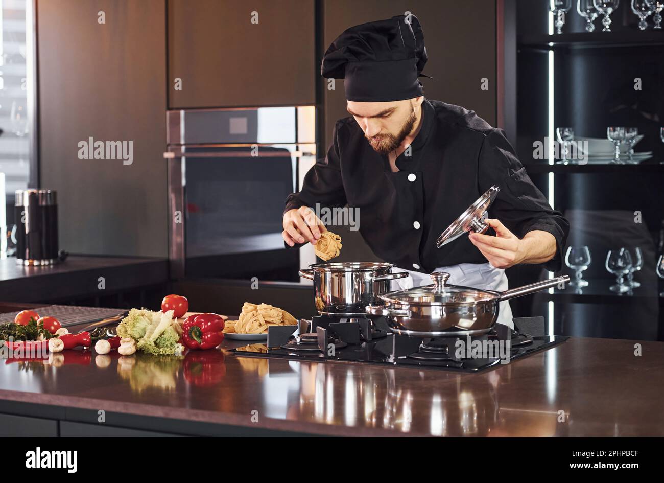 Using equipment. Professional young chef cook in uniform working on the ...