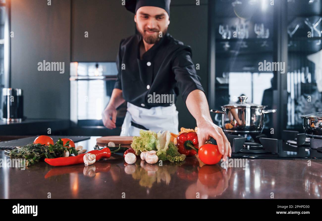 Preparing process. Professional young chef cook in uniform working on ...