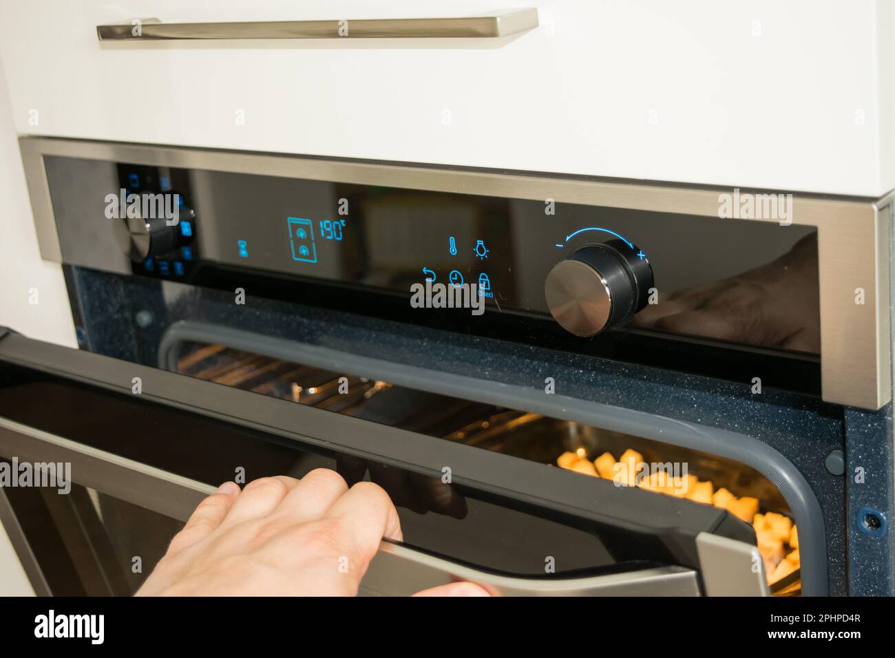 View of a male hand opening the oven Stock Photo - Alamy