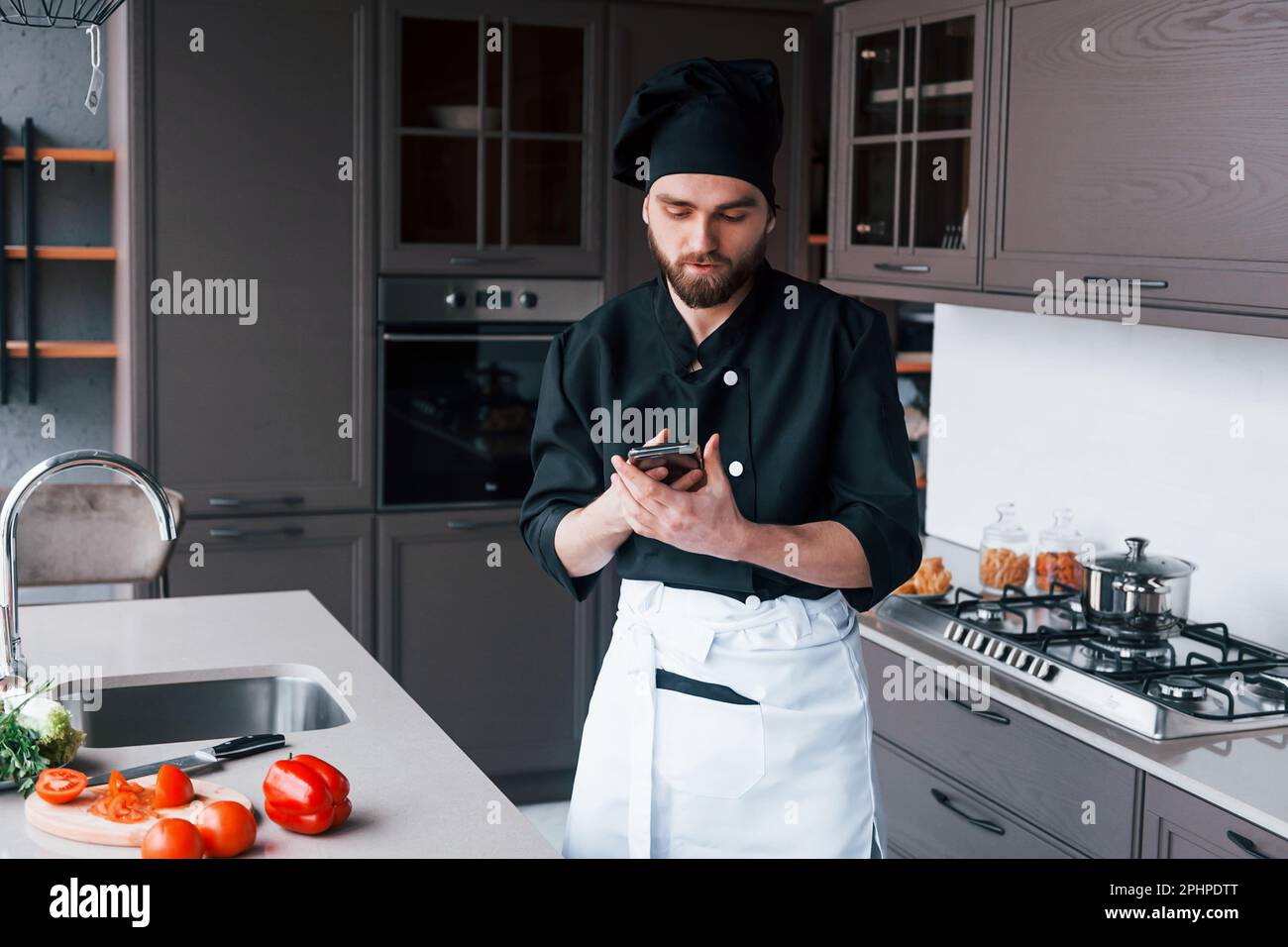 Professional young chef cook in uniform standing on the kitchen Stock ...