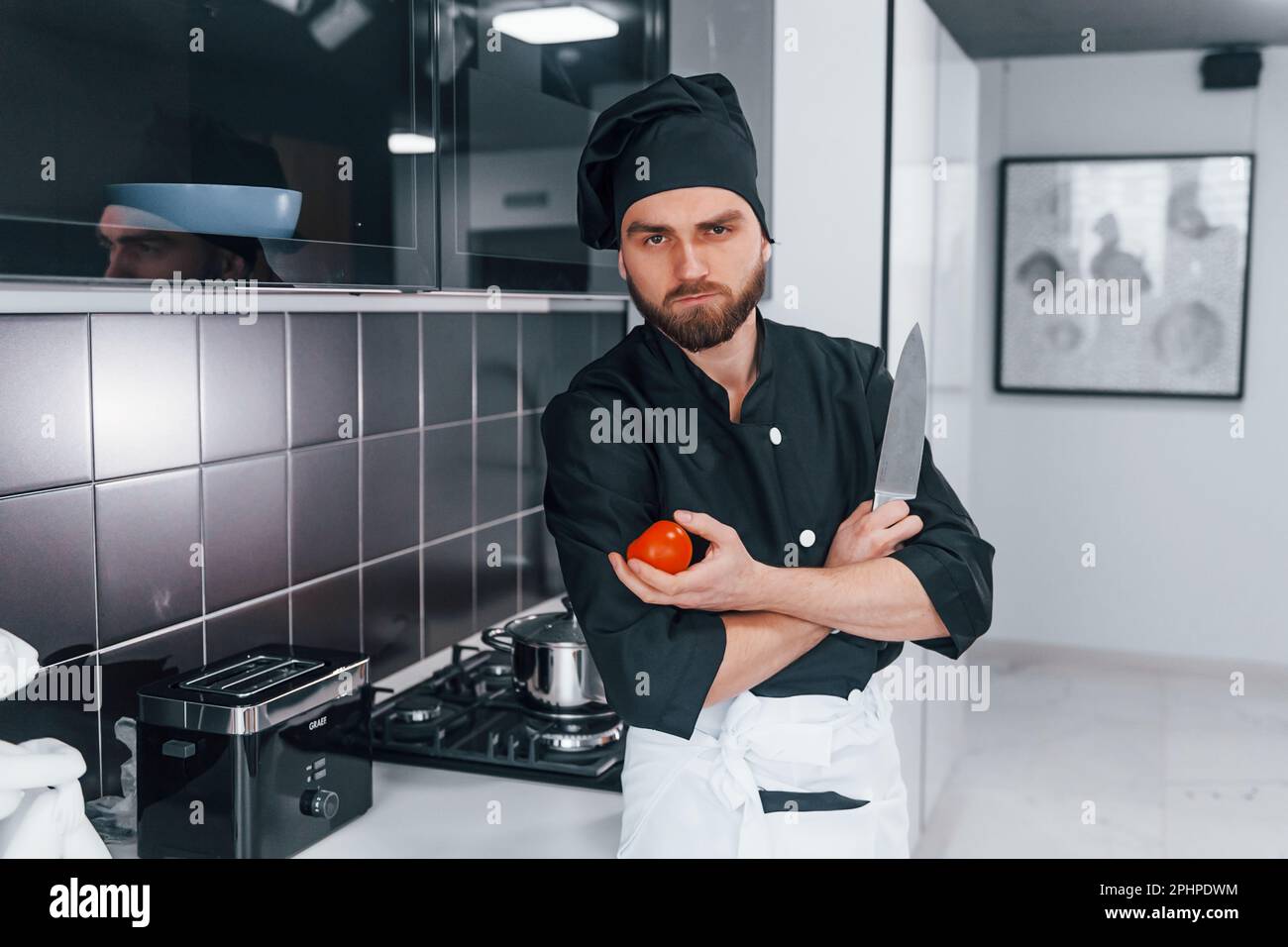 Professional young chef cook in uniform standing on the kitchen Stock ...