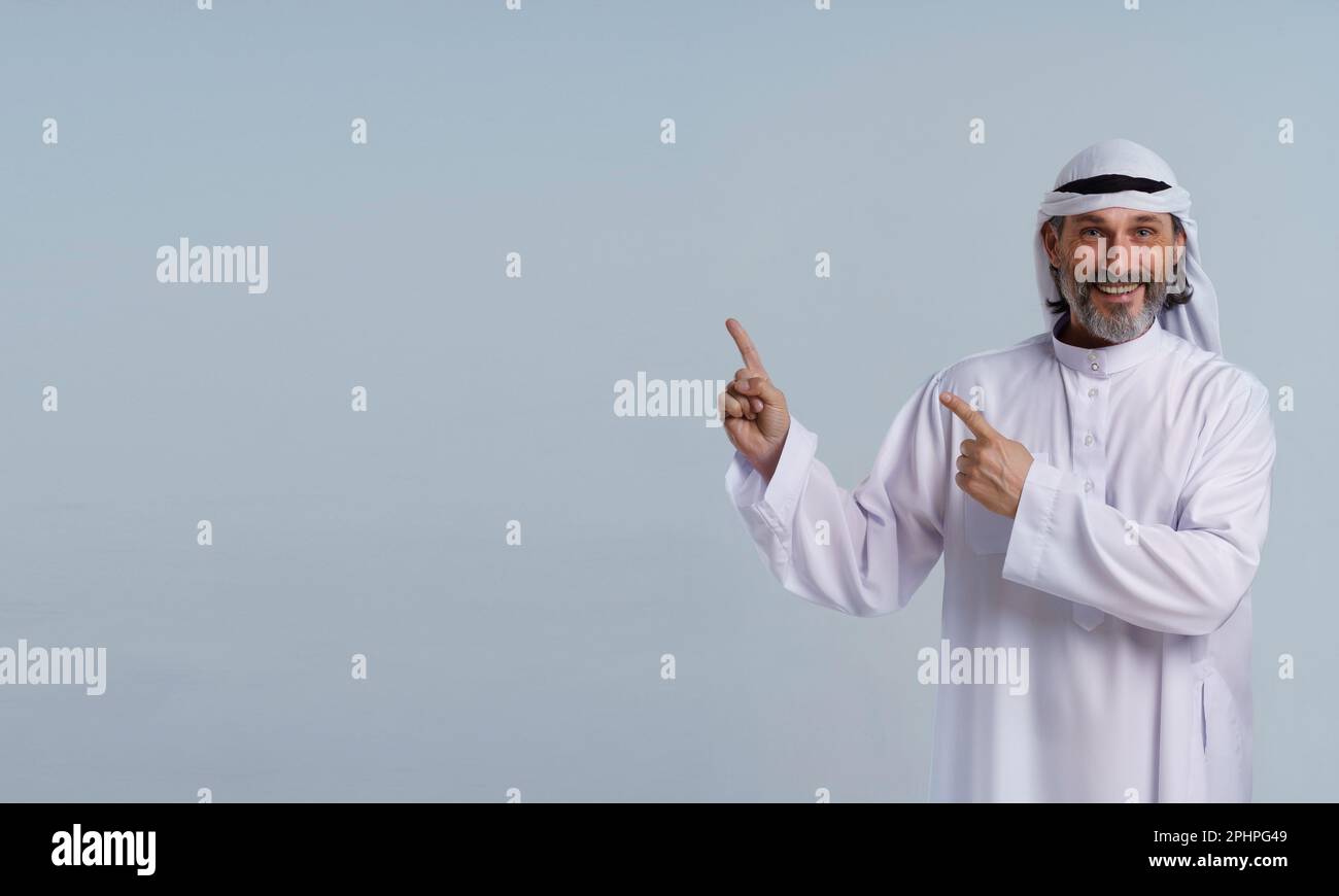 Arab man is with copy space. He is pointing his hands aside, indicating ...