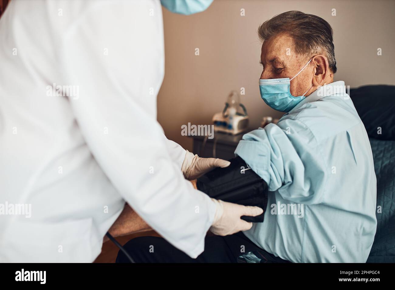 Doctor carying out blood pressure test and heart rate of senior man ...