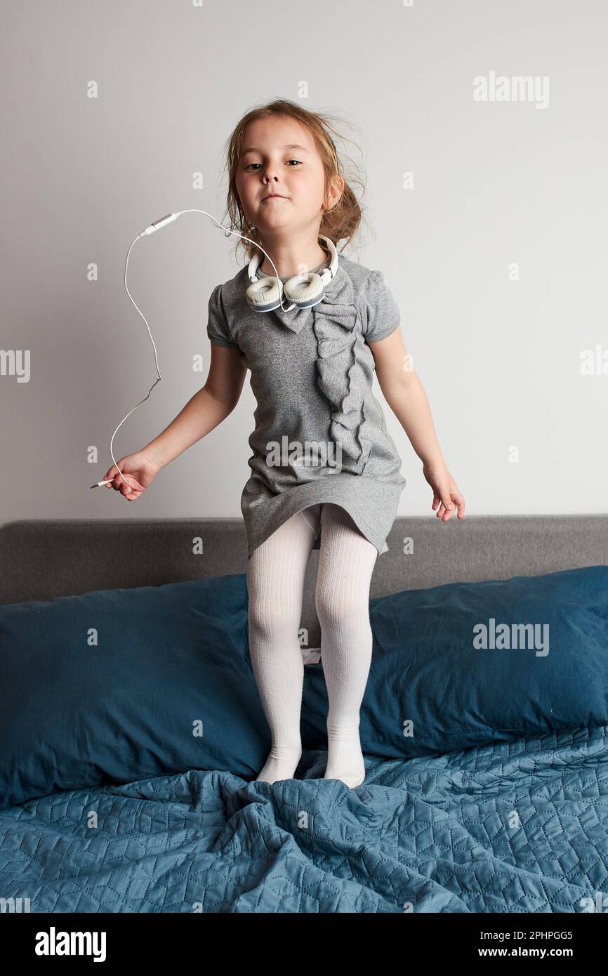 Little girl singing holding headphones cord imitating herself a real ...