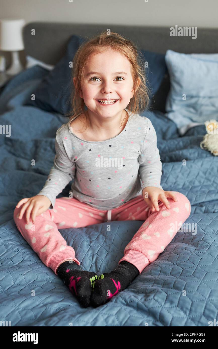 Little happy playful kid girl having fun making silly funny faces ...