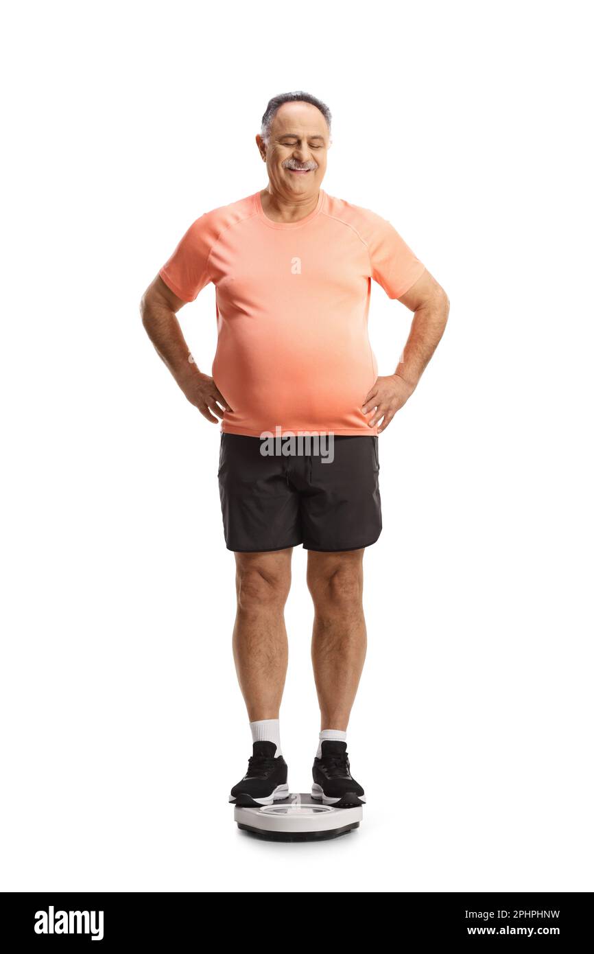 Mature man in sportswear standing on a weight scale and looking down ...