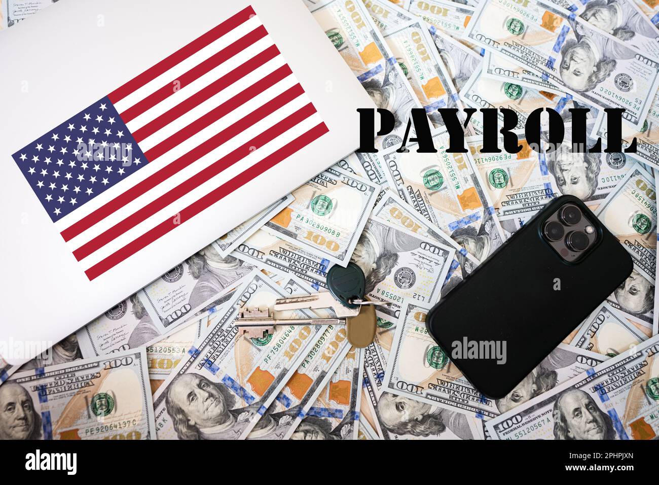 Payroll concept. USA flag, dollar money with keys, laptop and phone ...