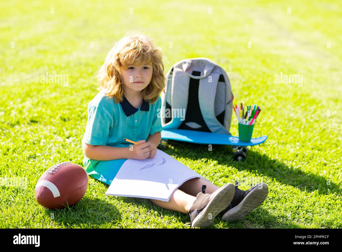Child play and draw craft artwork homework. School boy in park outdoor ...