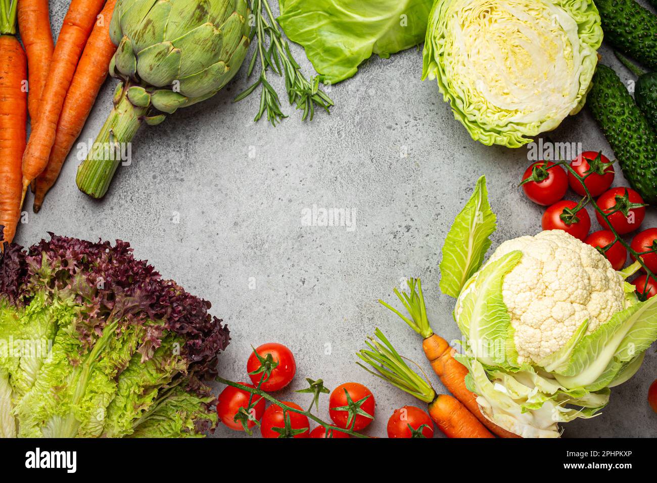 Fresh assorted organic vegetables on rustic grey stone table top view ...