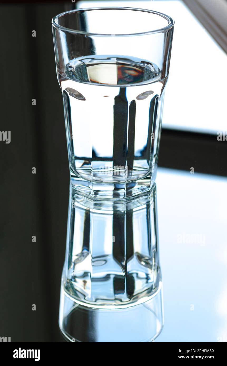 Reflection of a glass of spring water in the mirror Stock Photo - Alamy