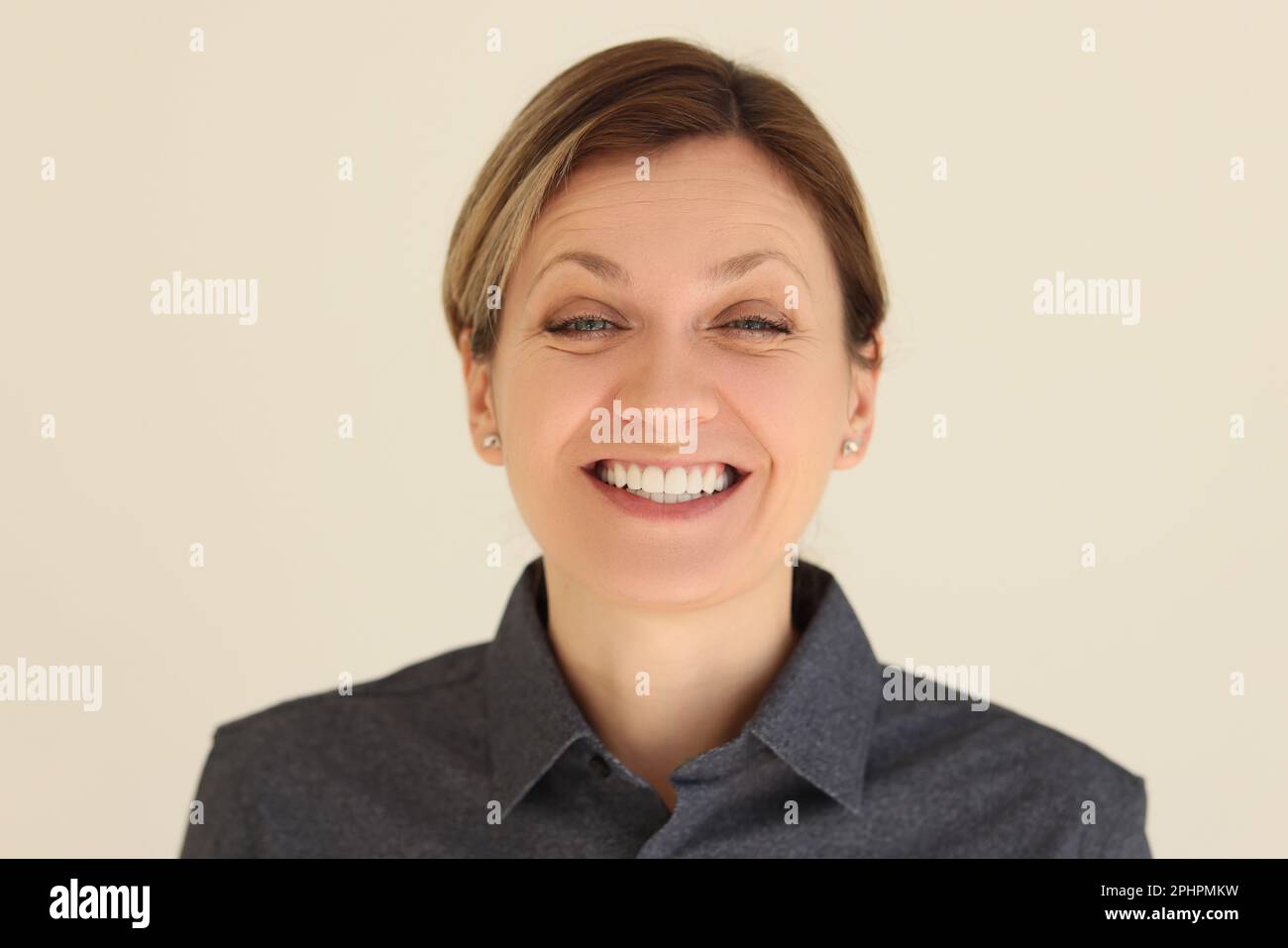 Blonde woman smiles broadly squinting and closing eyes Stock Photo - Alamy