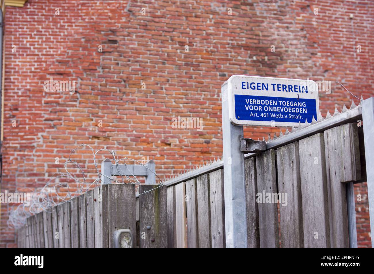 Dutch blue private property sign with in the background a stone wall ...