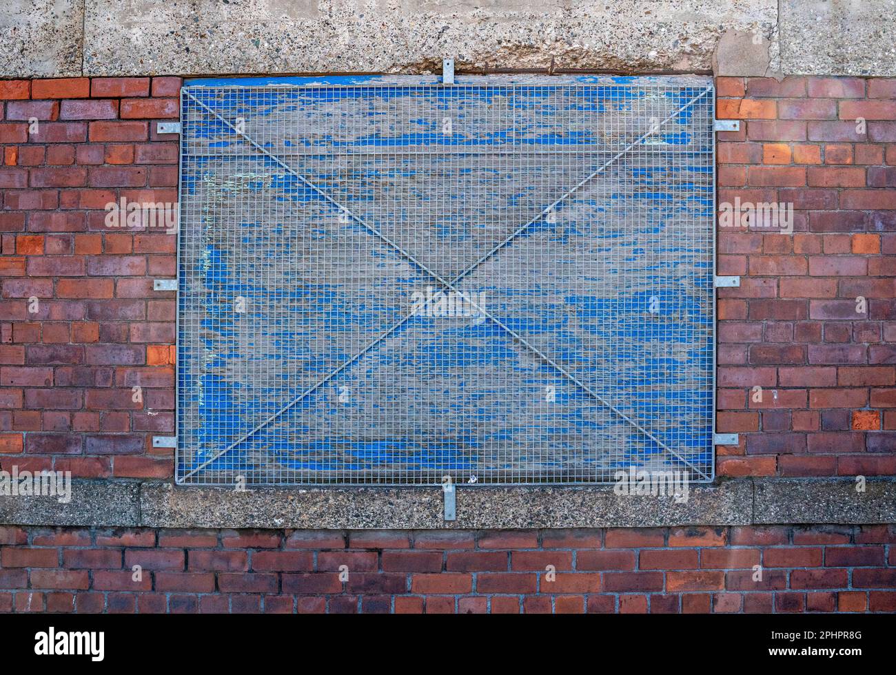 Warehouse window boarded up and protected by metal perforated security ...