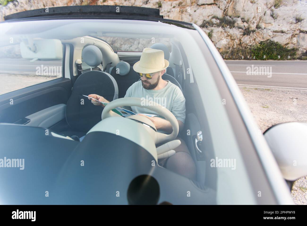 Hipster man looking on location navigation map in car, tourist traveler ...