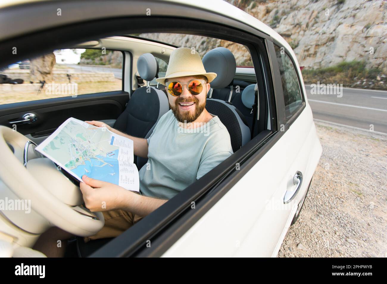 Hipster man looking on location navigation map in car, tourist traveler ...