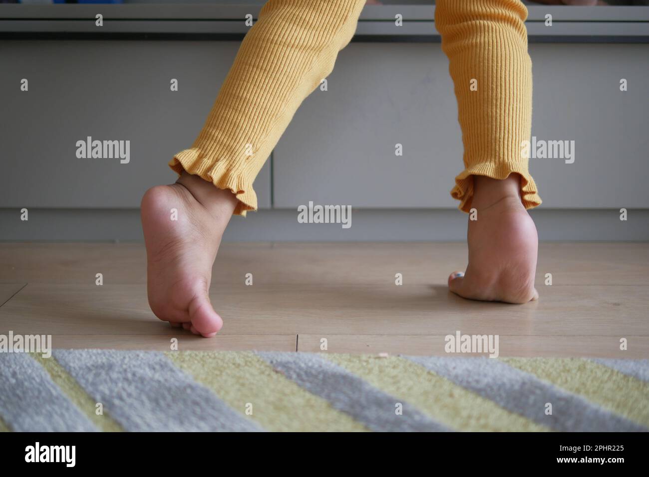 low angle view of A child walking on tiptoes Stock Photo - Alamy