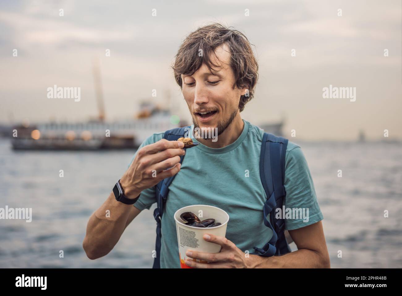 Heap of mussels in shells stuffed with rice. Man is going to eat midye ...