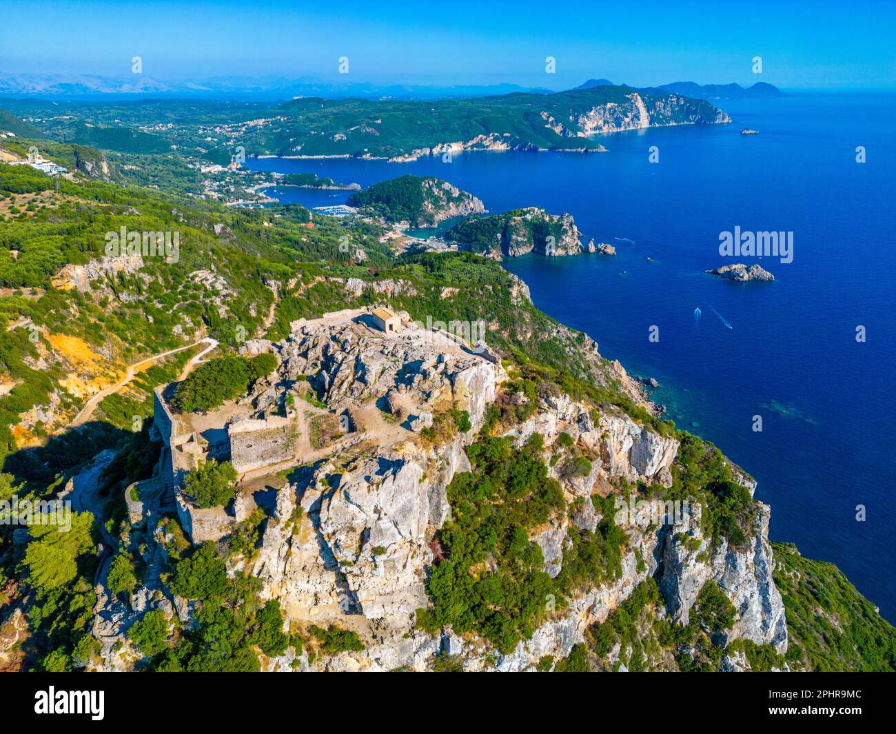 Aerial view of coastline of Paleokastritsa and Angelokastro castle on ...