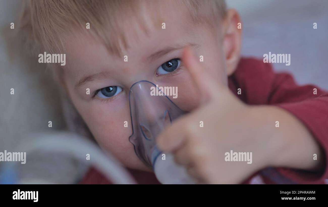 Funny boy breathing through an inhaler mask Stock Photo - Alamy
