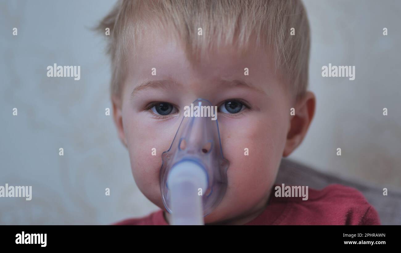 Funny boy breathing through an inhaler mask Stock Photo - Alamy