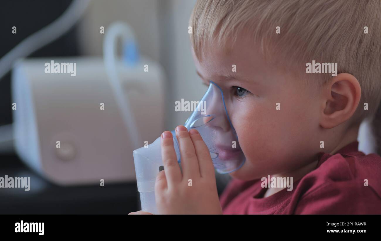 Funny boy breathing through an inhaler mask Stock Photo - Alamy