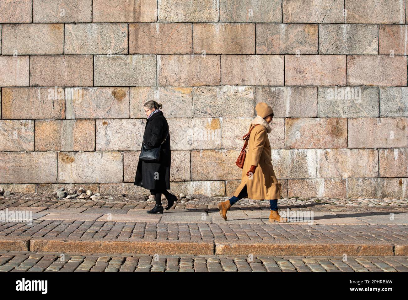 Two People Walking Down The Street