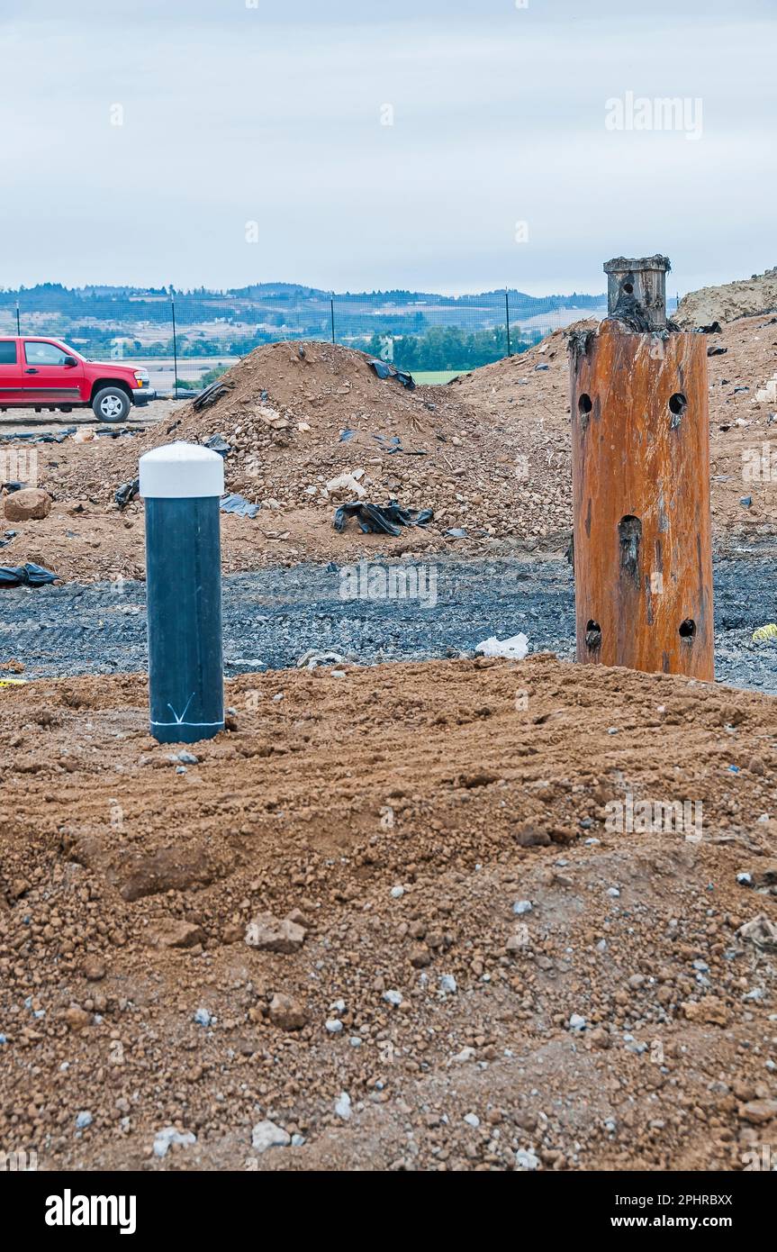 A vertical, capped pipe protruding from a mound of dirt in an active ...