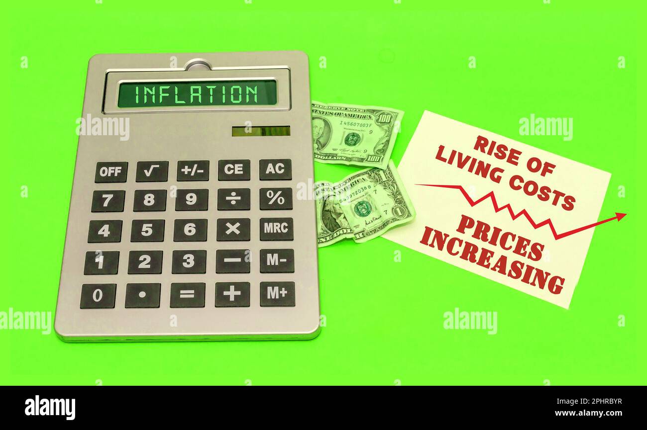 Dollar paper notes next to a calculator with note of rising prices due ...