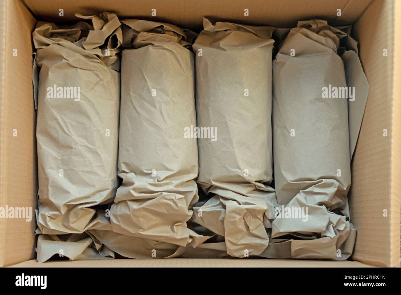 Fragile products wrapped up in paper and put in cardboard box for ...